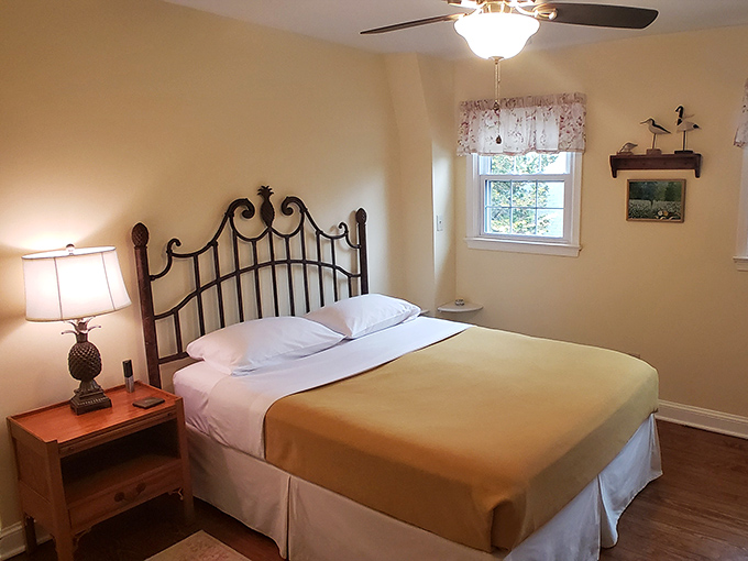 The Dunham Room's wrought iron bed frame whispers tales of simpler times, while the air conditioning quietly reassures you're still in the 21st century.