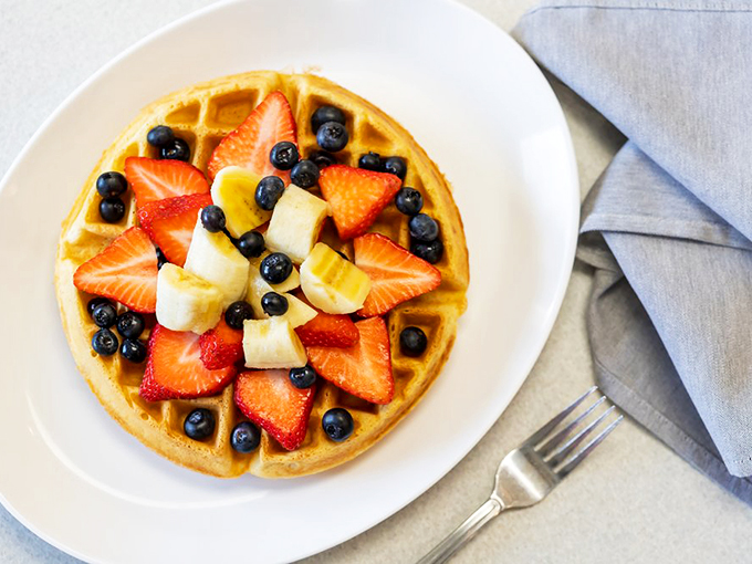 Nature's candy arranged in geometric precision atop a golden waffle canvas. Breakfast that's both Instagram-worthy and nutritionist-approved.