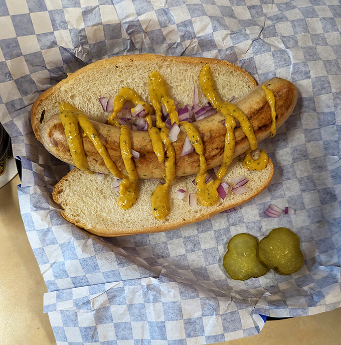 This bratwurst sandwich isn't just lunch; it's a vacation to Bavaria between two pieces of bread. Note the pickle standing guard. 