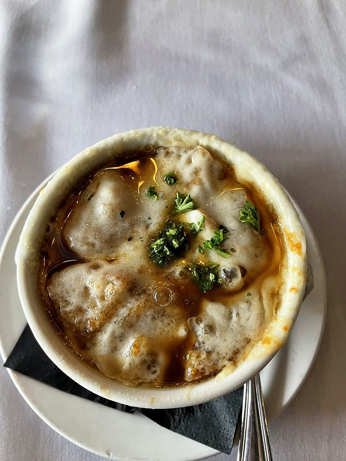 The moment of truth arrives with a spoon poised to break that glorious cheese barrier into the savory onion abyss below.