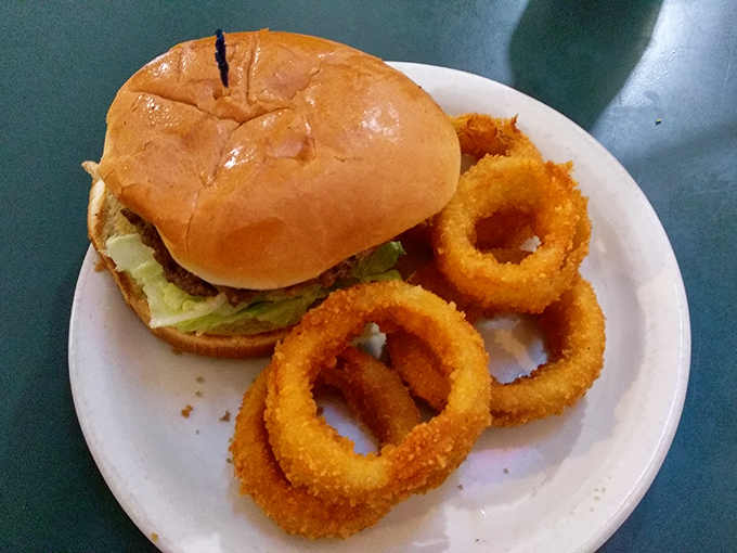 A classic burger with golden onion rings that crunch like autumn leaves. Simple pleasures executed with the precision of a Swiss train schedule.