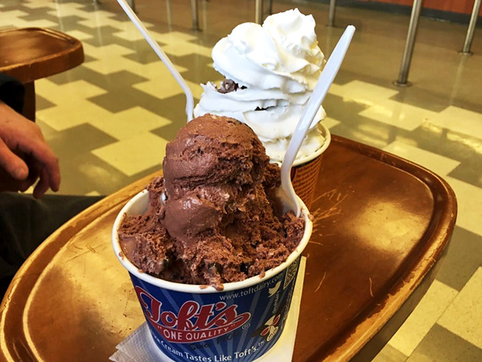 Chocolate so rich it should have its own tax bracket. The plastic spoon stands at attention, knowing it's in the presence of greatness.