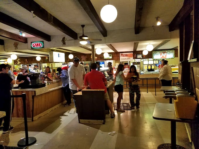 The concession stand hustle&mdash;where movie intermission transforms ordinary folks into strategic snack planners plotting their butter-to-popcorn ratios.