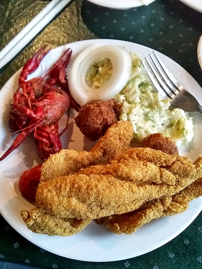 The holy trinity of Southern dining: perfectly fried catfish, golden hushpuppies, and fresh coleslaw. Simplicity that speaks volumes.
