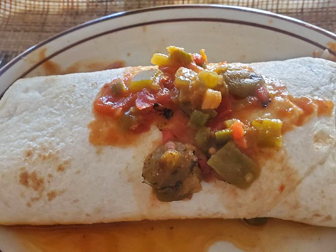 When your breakfast needs its own zip code: Frontier's burrito, gloriously smothered in chile that would make your abuela weep with joy.