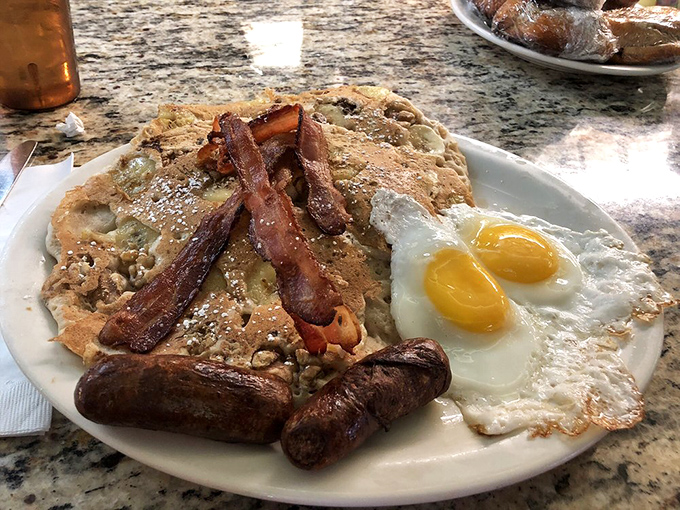 The holy trinity of breakfast perfection: golden pancakes, sunny-side-up eggs, and bacon that's achieved the ideal crisp-to-chew ratio.