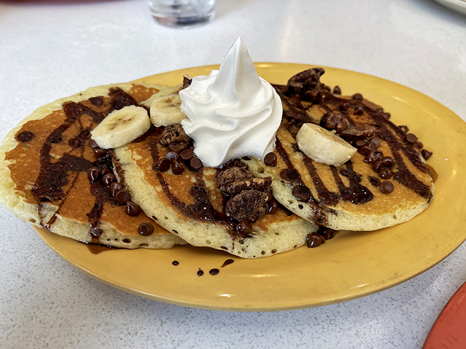 Chocolate chip pancakes topped with bananas, whipped cream, and chocolate – breakfast's answer to "Why choose between meals and dessert?"
