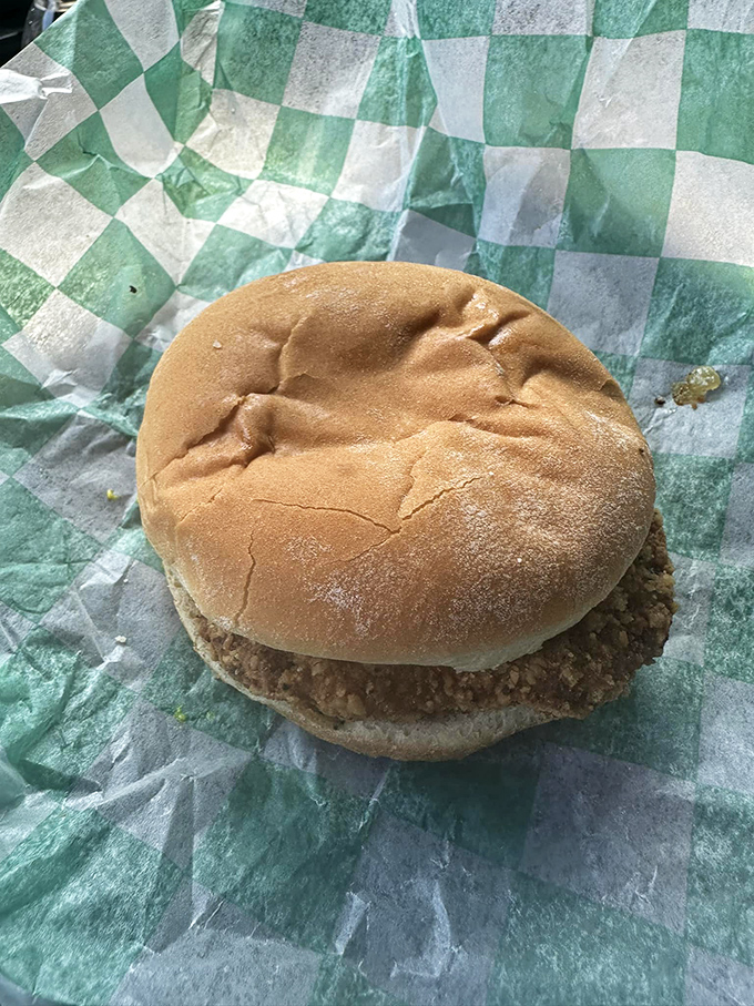 Simplicity at its finest: a hearty burger on a humble bun, wrapped in checkered paper &ndash; no Instagram filter needed.