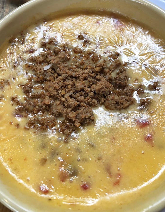Queso so good it should be illegal &ndash; molten cheese topped with seasoned ground beef that makes every chip a vehicle for happiness.