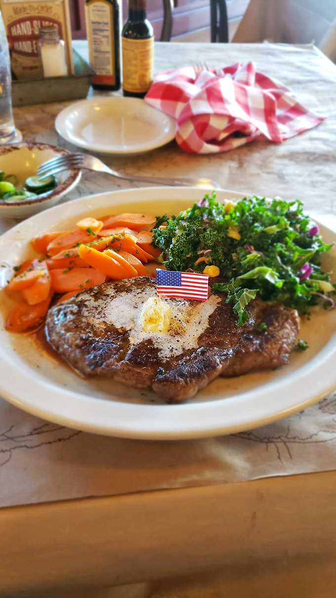 A perfectly seared steak with a pat of melting butter, flanked by vibrant vegetables and topped with a tiny Stars and Stripes&mdash;this isn't just dinner, it's an edible American dream.