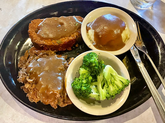 A study in contrasts: fork-tender roast beef alongside vibrant broccoli and mashed potatoes swimming in gravy that deserves its own philosophy course.
