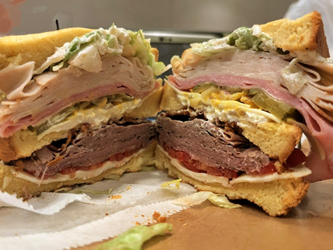 The architectural marvel of sandwich construction &ndash; multiple stories of meats, cheeses, and veggies between golden bread foundations. Skyscrapers wish they looked this good.