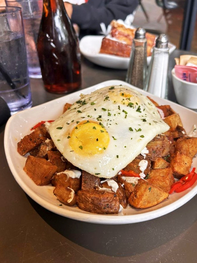 Potatoes crisped to perfection, crowned with an egg whose yolk is about to create the world's most delicious sauce. Breakfast architecture at its finest.