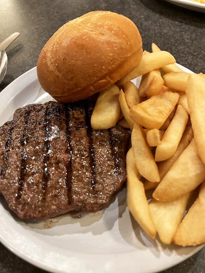 The holy trinity of steakhouse perfection: a juicy chopped steak, golden fries, and a roll that deserves its own fan club.