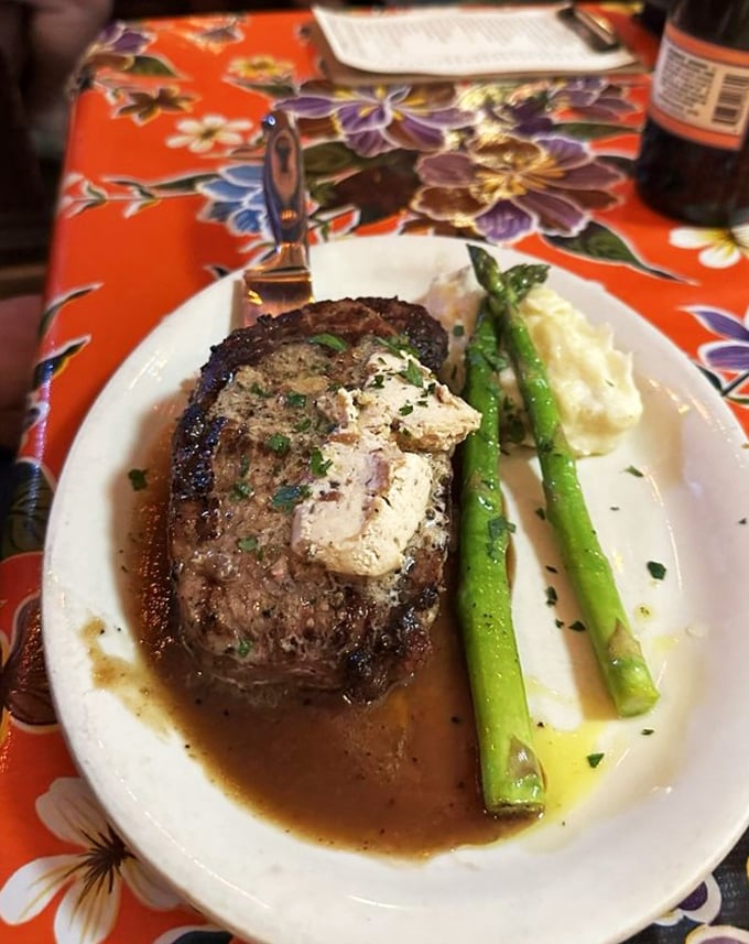 Enjoy your savory, butter-topped steak paired with crisp asparagus and creamy mashed potatoes for a satisfying and comforting local dinner.