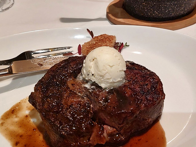A steak so perfectly cooked it deserves its own butler. That caramelized crust protecting the ruby-red interior is culinary architecture at its finest.