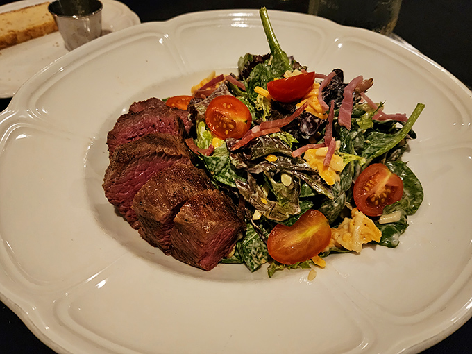 The kind of steak that makes conversation stop mid-sentence. Perfectly seared, paired with a vibrant salad that cuts through the richness like a well-timed joke. 