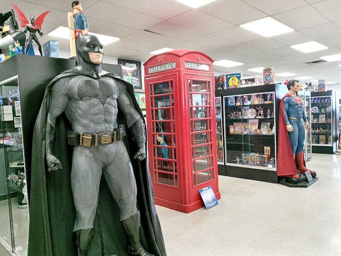 The trinity of heroes assembled: Batman's brooding presence, Superman's strength, and a British phone booth that could give Doctor Who a run for dimensional dominance.