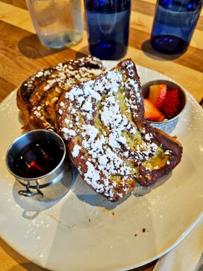 Thick-cut French toast stacked high with that perfect caramelized exterior. The small cup of berries is just pretending you're being healthy &ndash; and we're all in on the delicious deception.