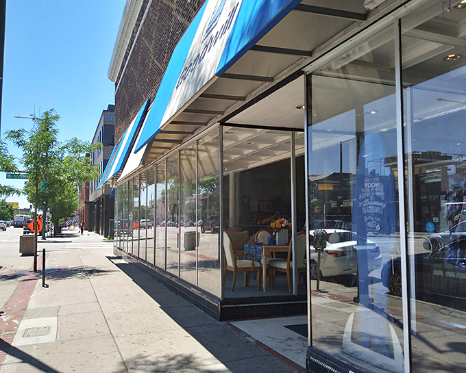 Goodwill's Broadway location brings vintage charm with those distinctive blue and white awnings framing windows of possibility.