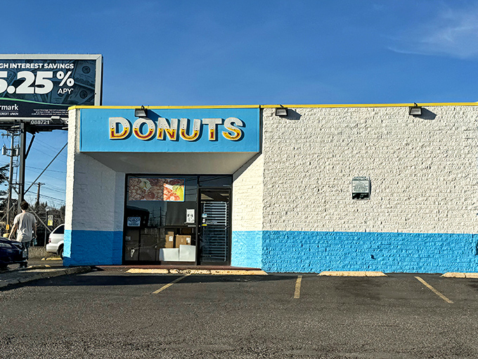 Heavenly Donuts' blue-trimmed sign against gray Oregon skies &ndash; a 24-hour beacon of sweet comfort. 