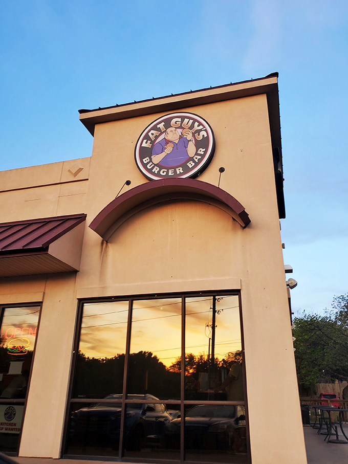 As the sun sets behind Fat Guy's, burger dreams come alive. That purple sign promises satisfaction for serious appetites only.