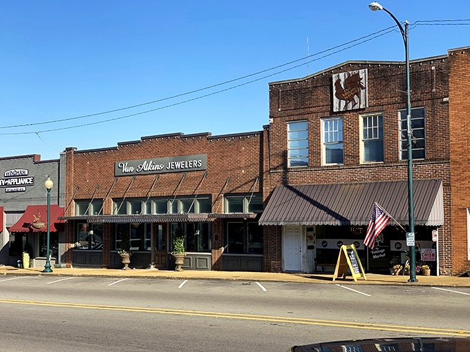 Awnings and brick storefronts create New Albany's perfect small-town silhouette against a clear Mississippi sky.