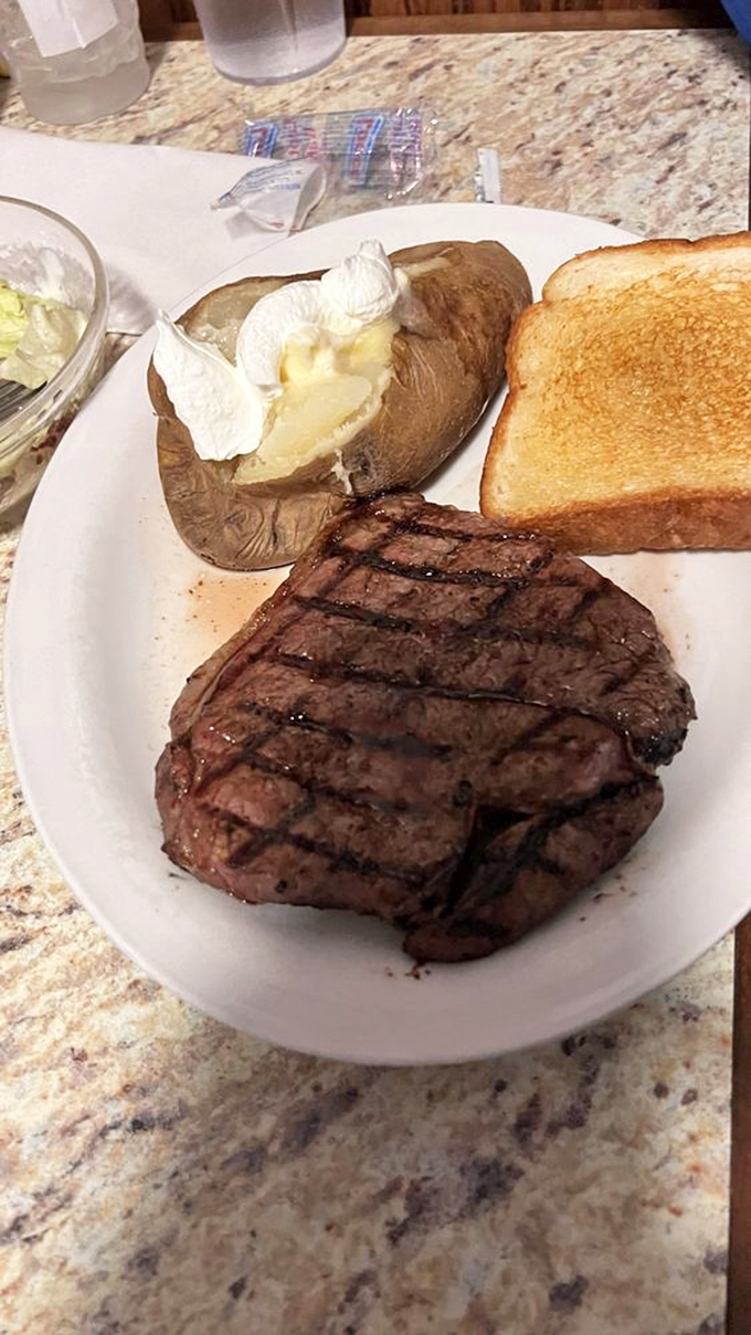 This 14oz ribeye isn't just a steak&mdash;it's a statement. With that butter-loaded baked potato and golden toast, it's comfort food elevated to art form.