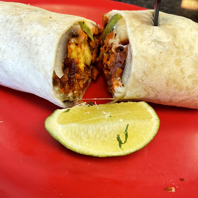 Cut in half to reveal its secrets, this al pastor burrito showcases the perfect marriage of spiced meat, fresh vegetables, and that essential hint of lime.