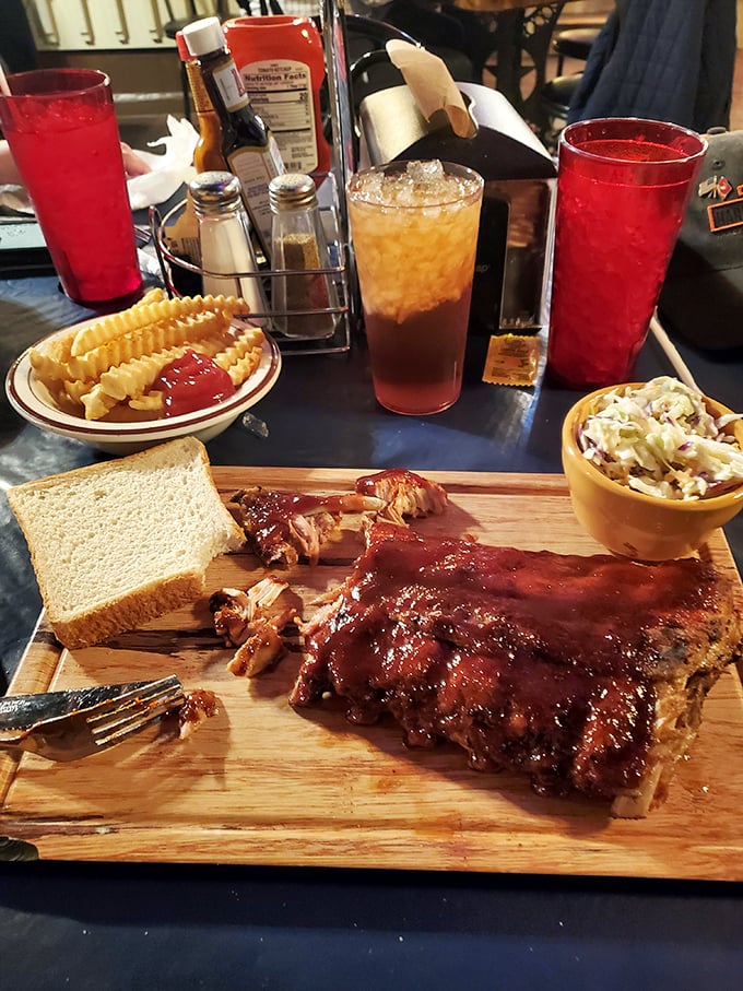 Ribs so tender they practically surrender to your fork, served with all the fixings on a wooden board that screams "authentically rustic."