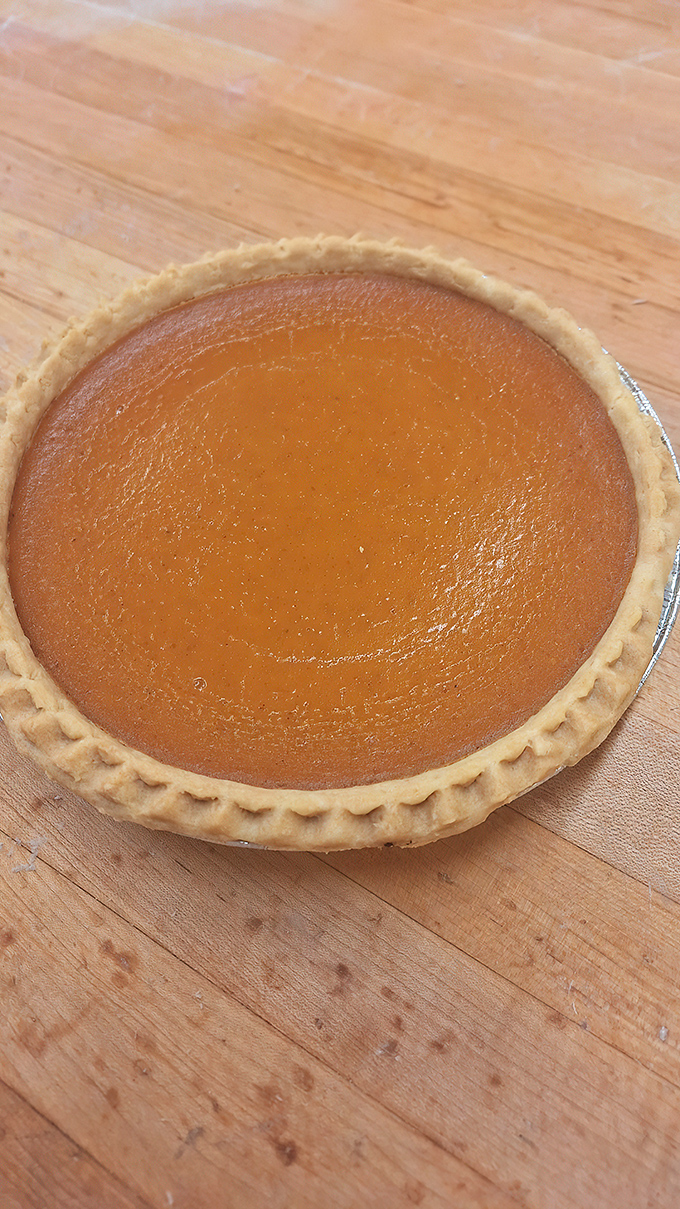 The crimped edges of these pumpkin pies aren't just decorative – they're the baker's signature, like Picasso signing a masterpiece.
