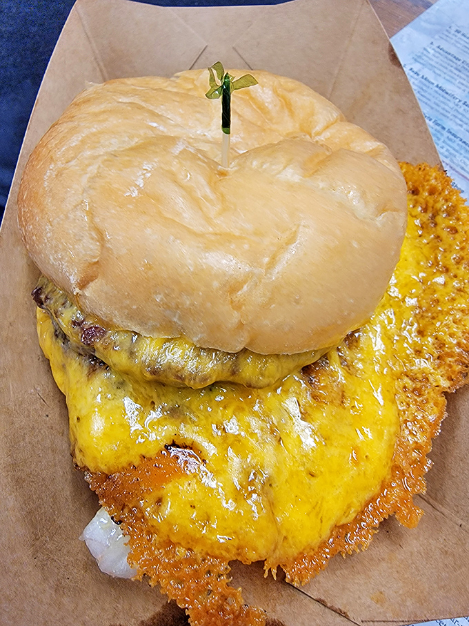This isn't just a burger; it's a commitment. The golden-brown bun barely contains its treasures, while that cheese skirt demands your full attention.