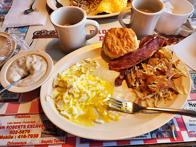 Breakfast perfection on a plate&mdash;fluffy scrambled eggs, crispy bacon, golden hashbrowns, and a biscuit that would make your grandmother both jealous and proud.