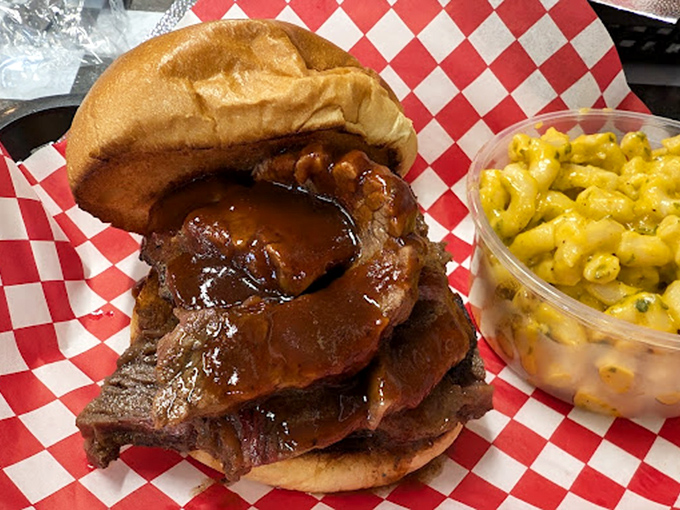 This brisket sandwich isn't just a meal; it's an architectural marvel of meat, sauce, and bun that requires both hands and zero shame.