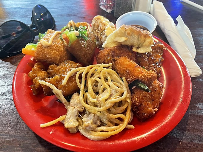 The beautiful chaos of a buffet plate in its natural habitat. Lo mein mingling with crispy chicken while noodles make a break for freedom.