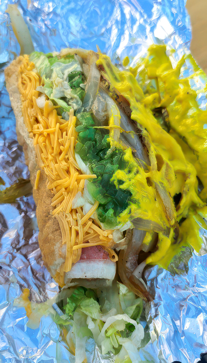 Layer upon layer of green freshness, golden cheese, and mustard zest&mdash;proof that a hot dog can be both canvas and masterpiece.