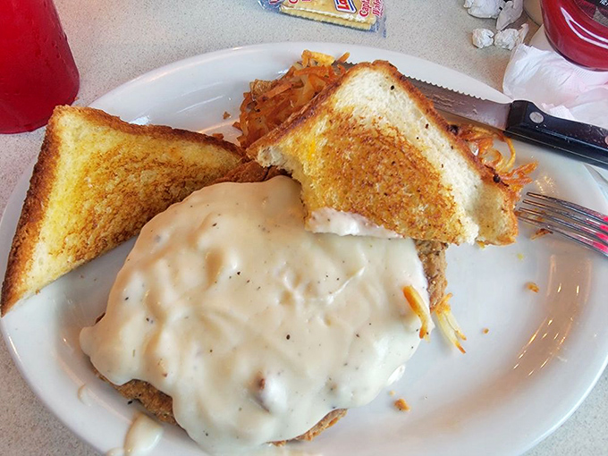 Gravy isn't just a topping here; it's a warm, peppery blanket tucking in a perfectly crisp chicken fried steak for a nap.