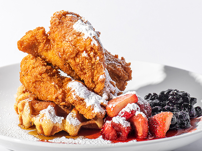 Chicken and waffles with berries and powdered sugar &ndash; breakfast, lunch, and dessert having a party on one magnificent plate.