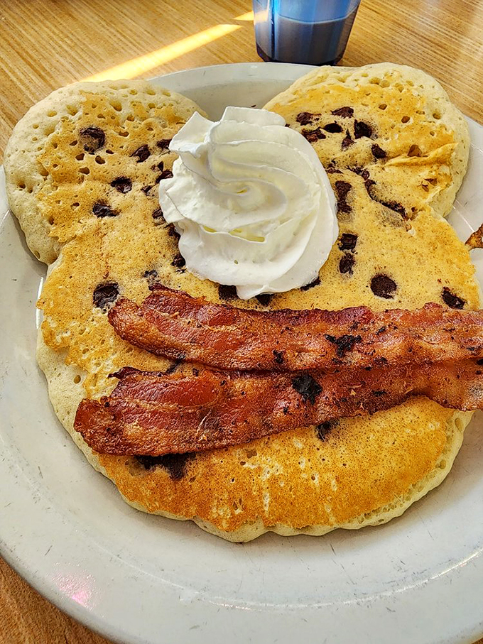 Chocolate chip pancakes topped with whipped cream and bacon&mdash;proof that sometimes the best breakfast decisions are the least responsible ones.