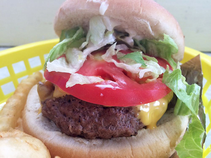 The classic cheeseburger in its natural habitat &ndash; nestled in a yellow basket, beckoning with that perfect ratio of meat to cheese to bun.