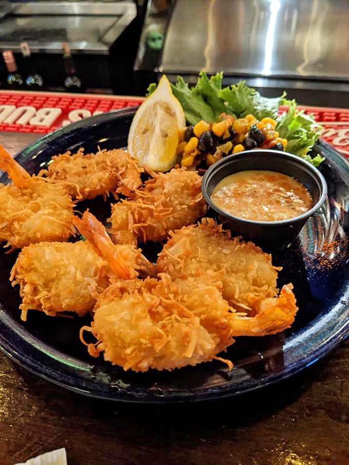 These coconut shrimp aren't just fried, they're transformed – crispy, golden armor protecting sweet seafood within, served with a dipping sauce that ties it all together.