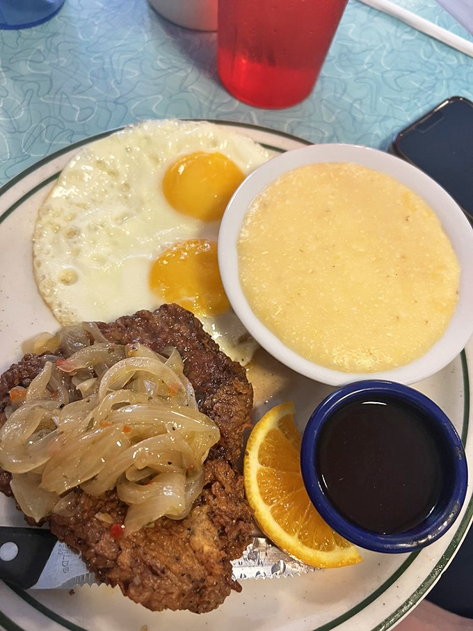 Country fried steak with golden eggs and creamy grits&mdash;the holy trinity of Southern breakfast. Add caramelized onions and you've got breakfast nirvana.