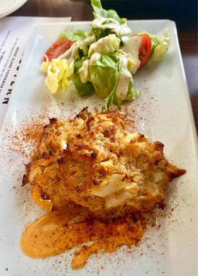 Crab cake artistry at its finest &ndash; where sweet lumps of crab meet a crispy exterior, all drizzled with a sauce worth bottling and taking home.