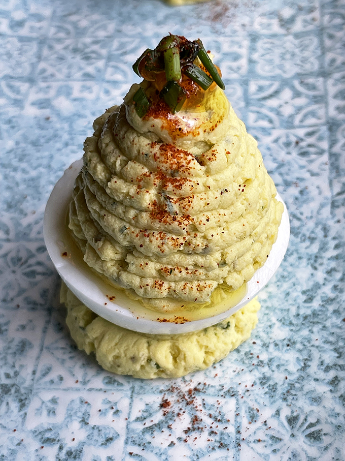The deviled egg – reimagined as a sculptural masterpiece. That orange roe on top is like jewelry for food that already looks too good to eat.