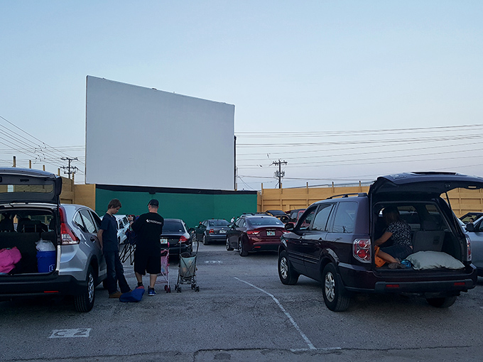Families arrive early to claim their spots and set up their viewing nests. The tailgate picnic is as much a part of the experience as the movie itself.