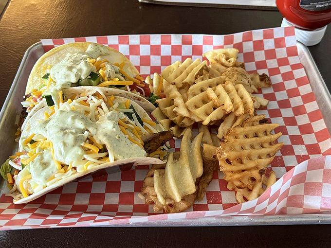Fresh greens cradle a golden-fried fish filet while waffle fries stand at attention—a sandwich that demands both hands and your full attention.