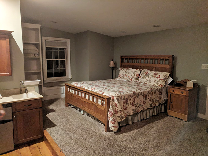 Country comfort meets modern amenities in this cozy guest room, where the handcrafted bed frame whispers stories of Pennsylvania craftsmanship.