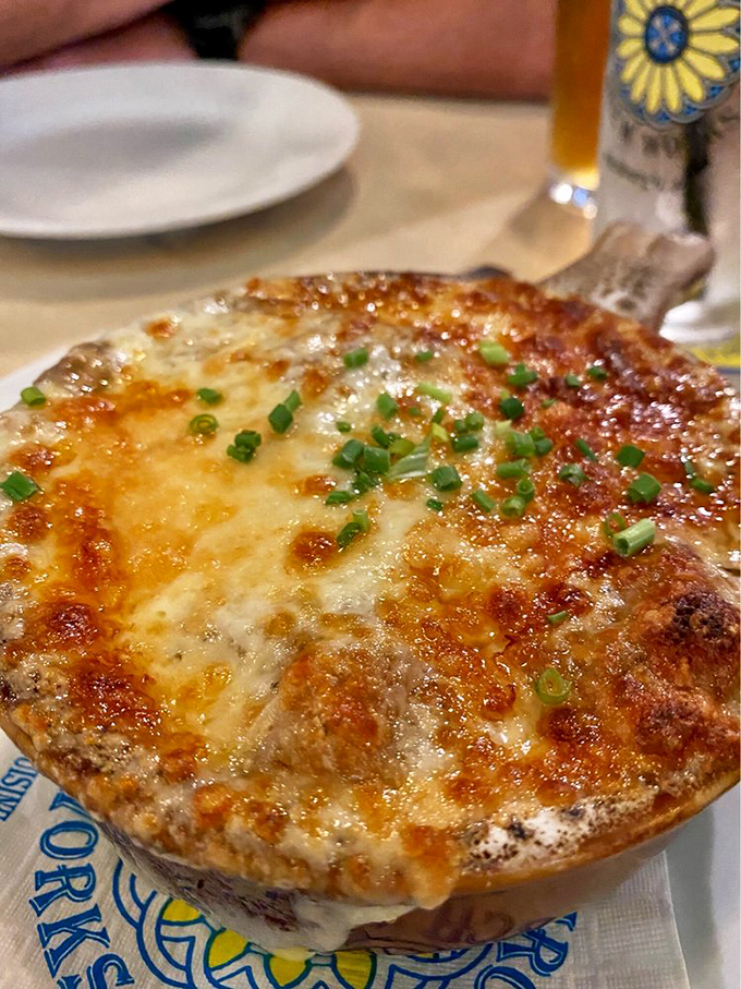 This French onion soup, crowned with a golden halo of melted provolone, might just inspire more devotion than the original building's sermons.