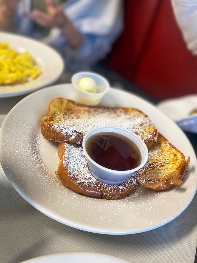 Golden-edged French toast dusted with powdered sugar snow beside a maple syrup lake&mdash;breakfast doesn't get more photogenic than this plate of morning perfection.