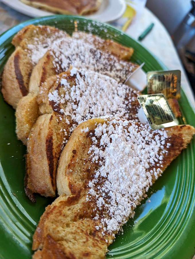 French toast that puts France to shame, dusted with powdered sugar like the first perfect snowfall on a Colorado mountain. Each bite is a sweet surrender to breakfast bliss.